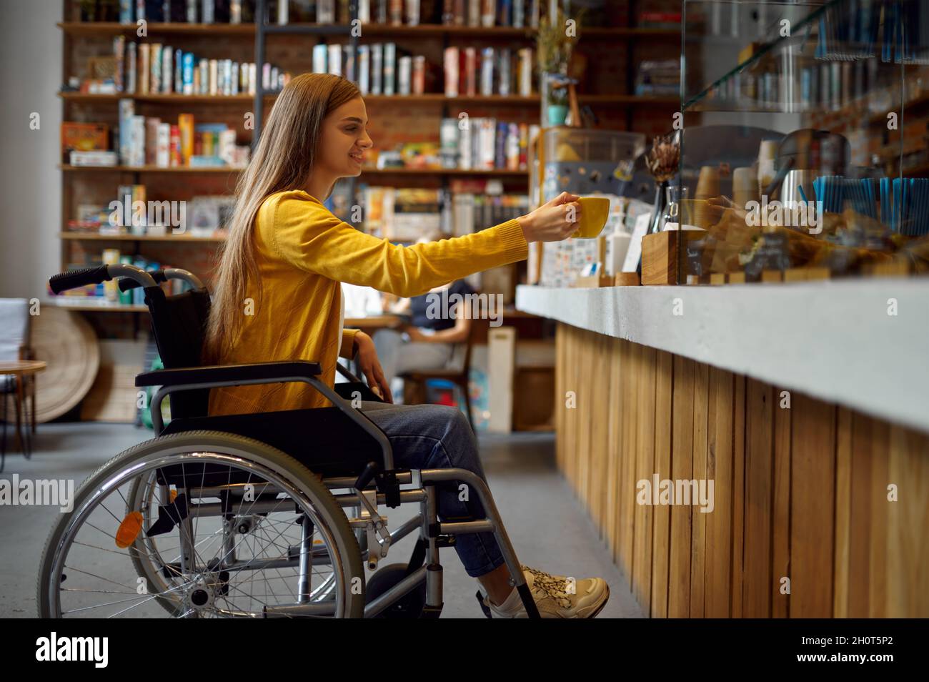 Disabled female student in wheelchair in cafe Stock Photo - Alamy
