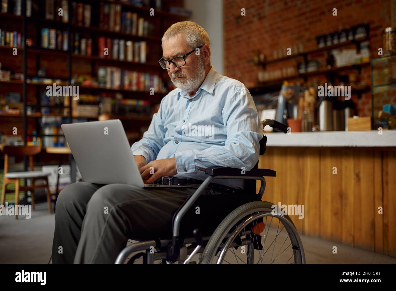 Adult disabled man in wheelchair using laptop Stock Photo - Alamy