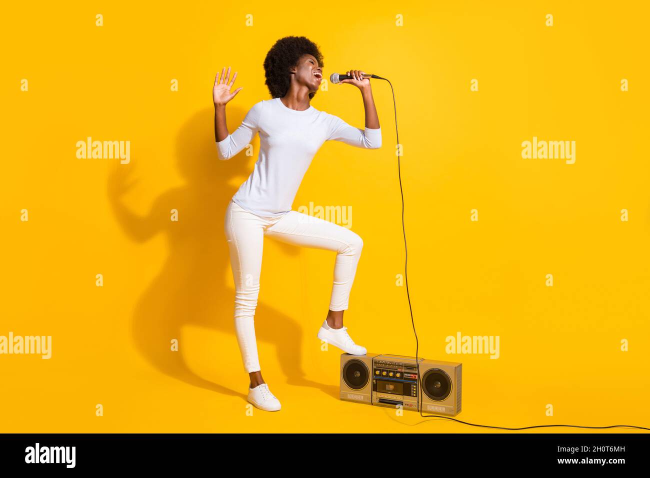 Full size photo of carefree excited dark skin lady singing leg on ...