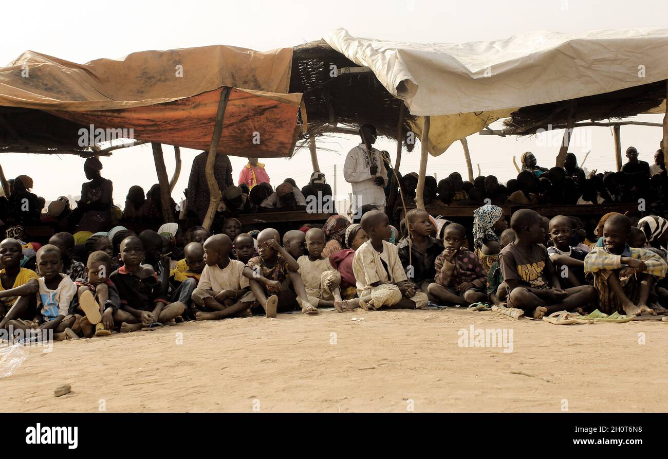 Displaced children being publicly addressed during a general assembly ...