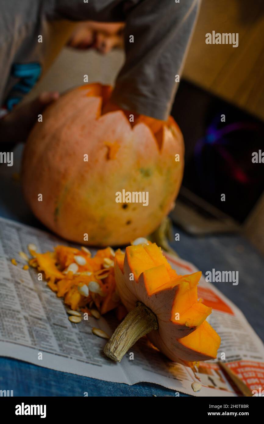 Child carves from a pumpkin. family fun activity. arved pumpkins into ...