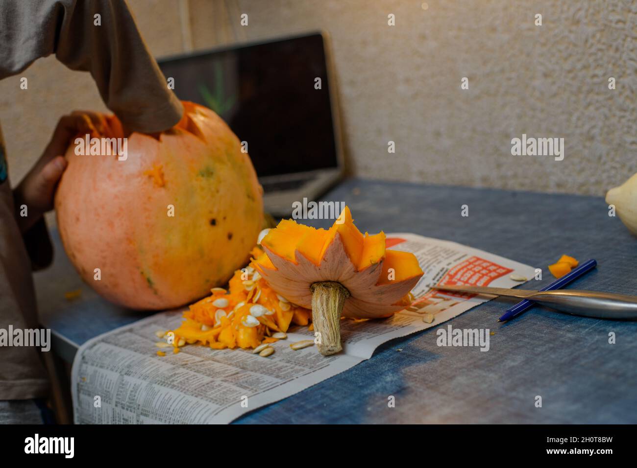 Child carves from a pumpkin. family fun activity. arved pumpkins into ...