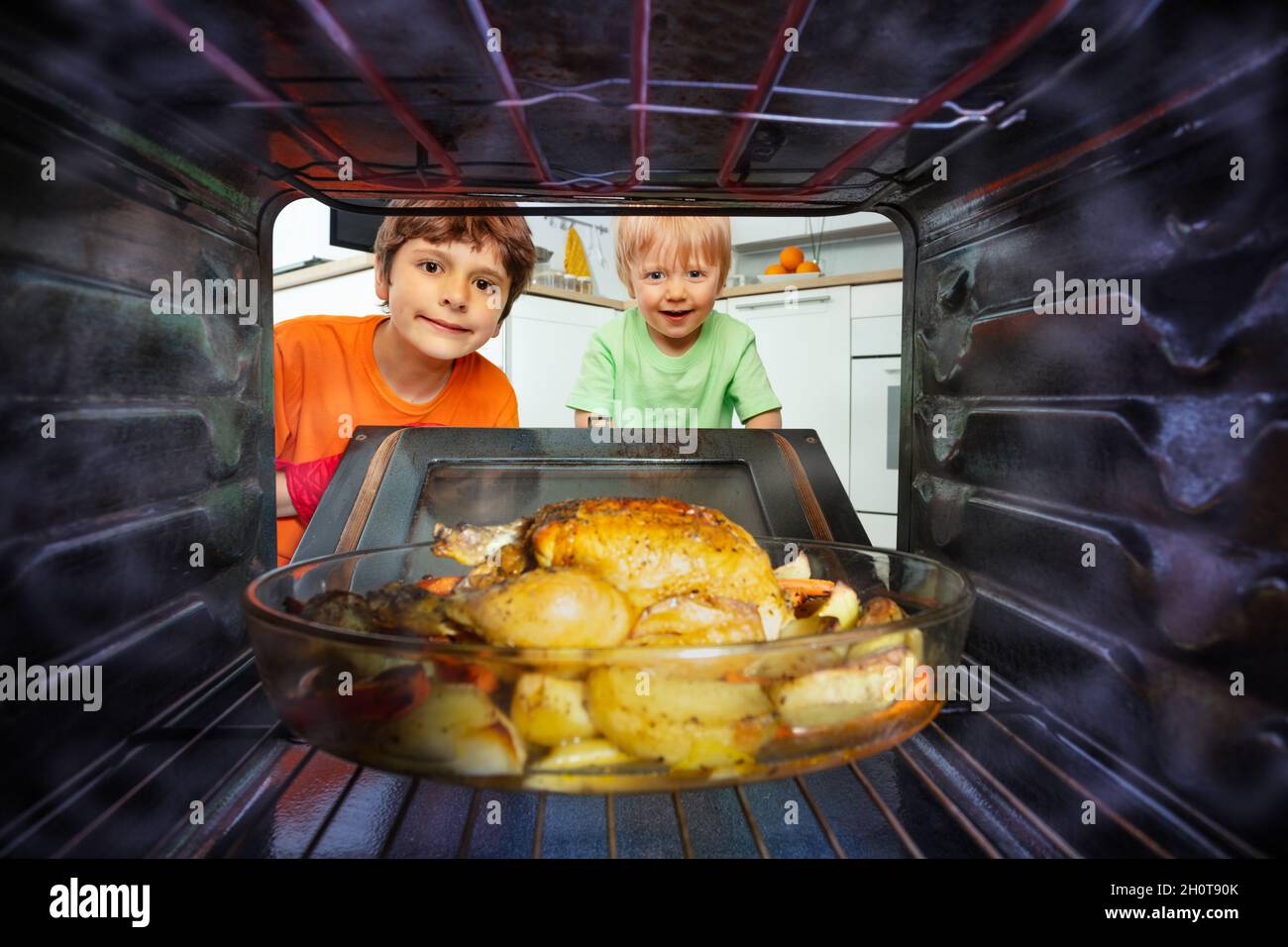 Two little boys open oven to take fried chicken Stock Photo - Alamy