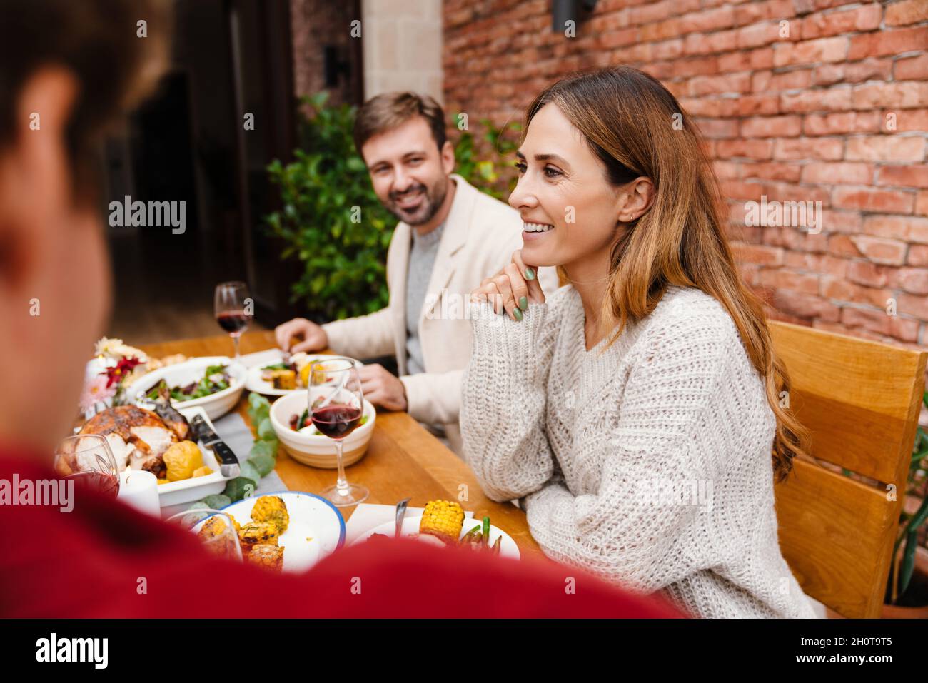 Multiracial happy friends smiling and talking during thanksgiving ...