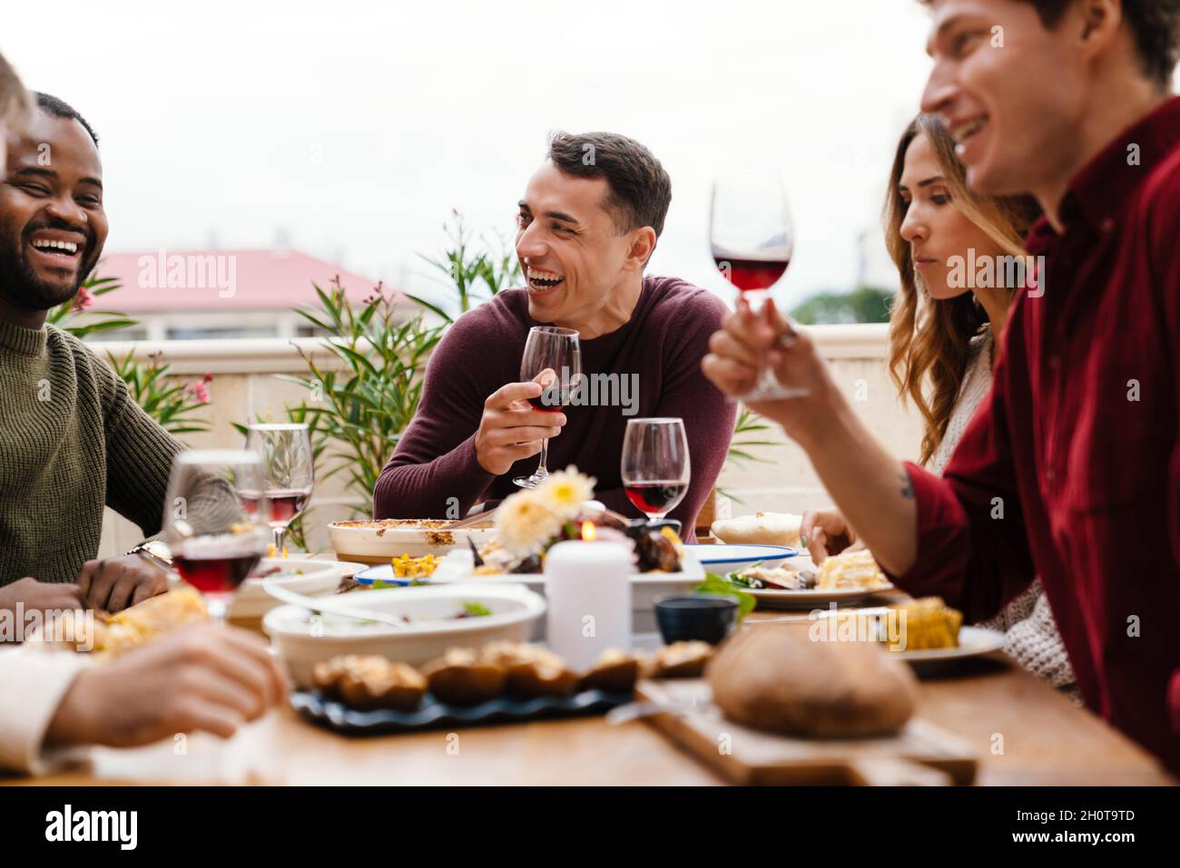Multiracial happy friends laughing and talking during thanksgiving ...