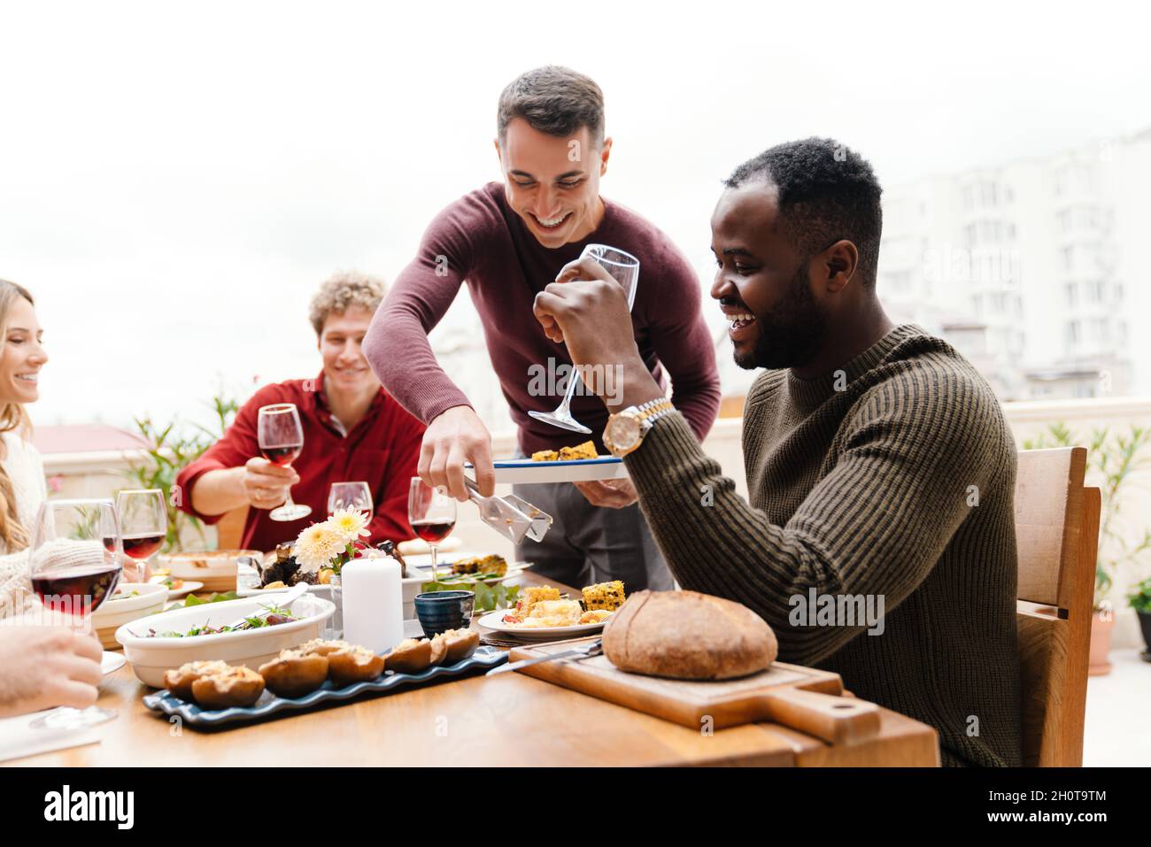 Multiracial happy friends laughing and talking during thanksgiving ...