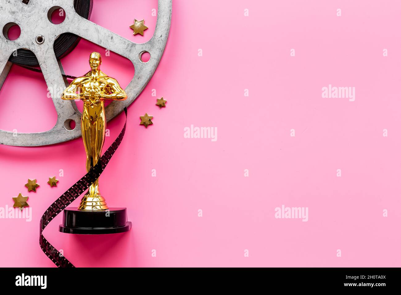 Golden film award statue with reel video tape Stock Photo - Alamy