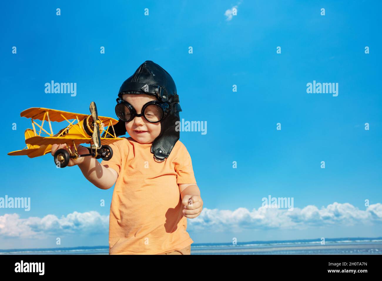 Little boy in aviator hat play with toy biplane Stock Photo - Alamy