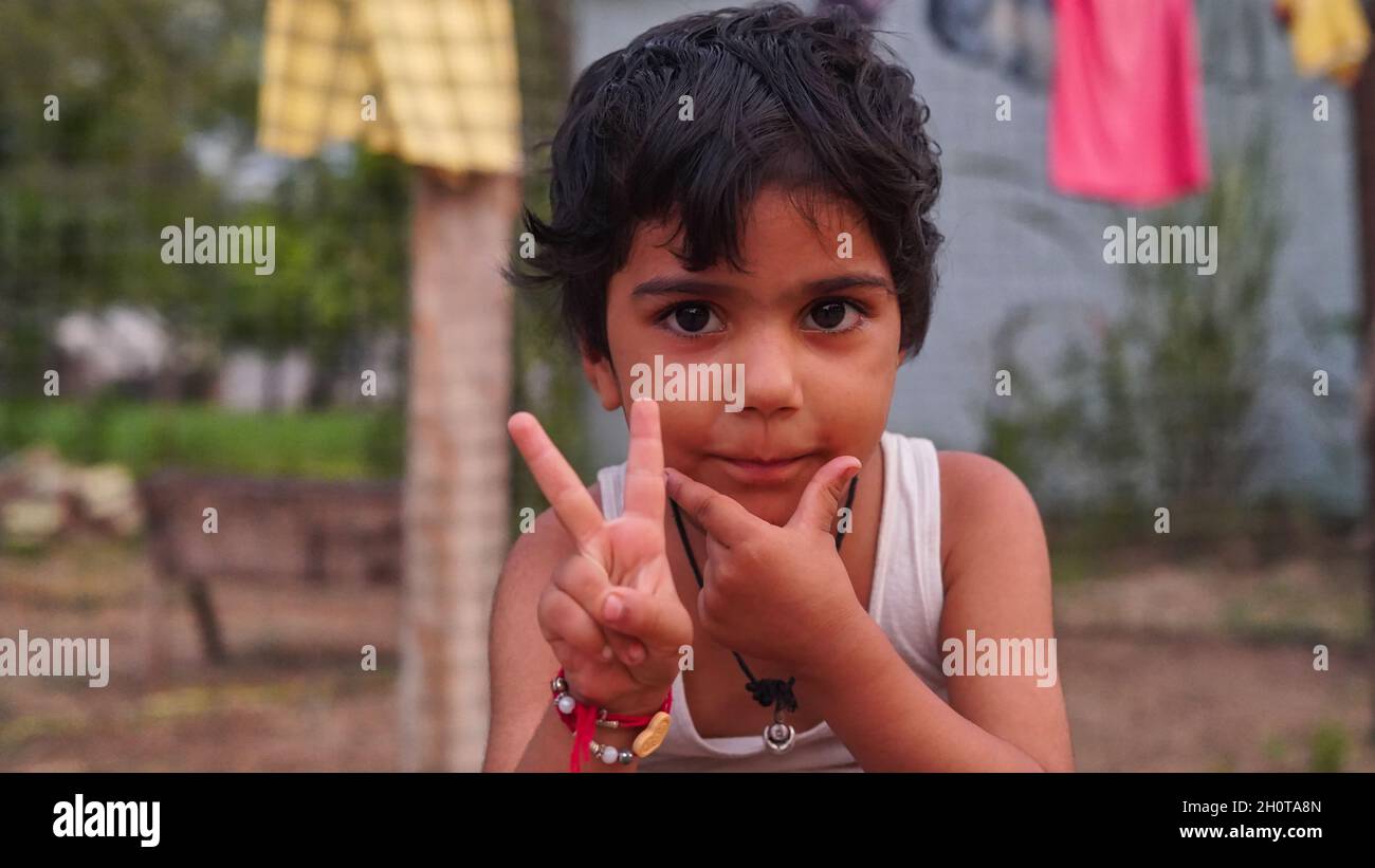 Close up shot of an Asian smiling young girl showing two fingers, the ...