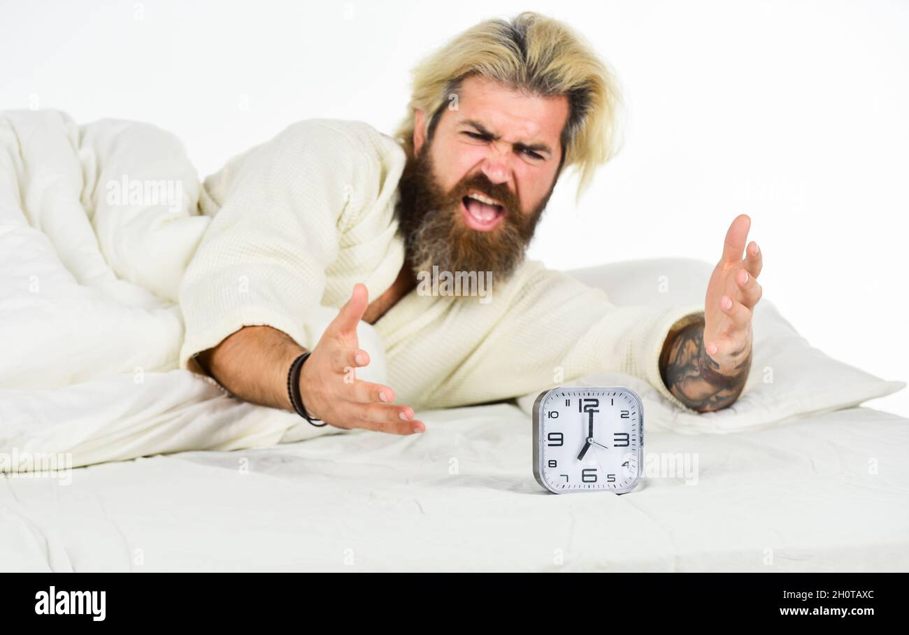 Destroy the Clock. handsome angry man lies in bed indoors wake up turn ...