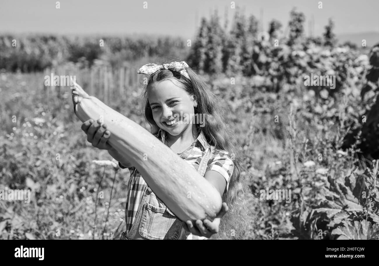 portrait of happy kid with vegetable marrow. cheerful retro child hold ...