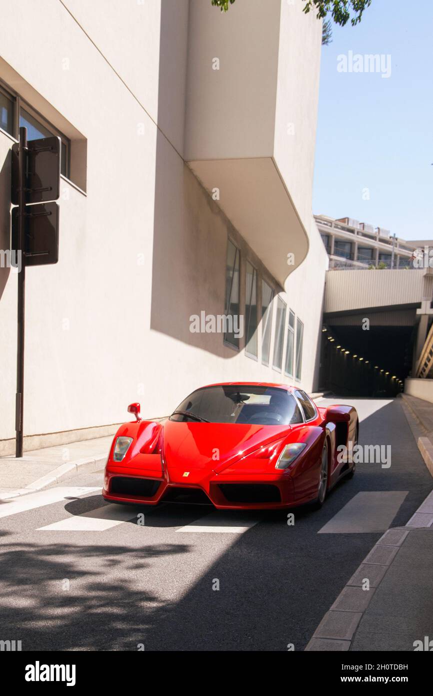 Red Ferrari Enzo classic supercar driven on a street of central Monaco ...