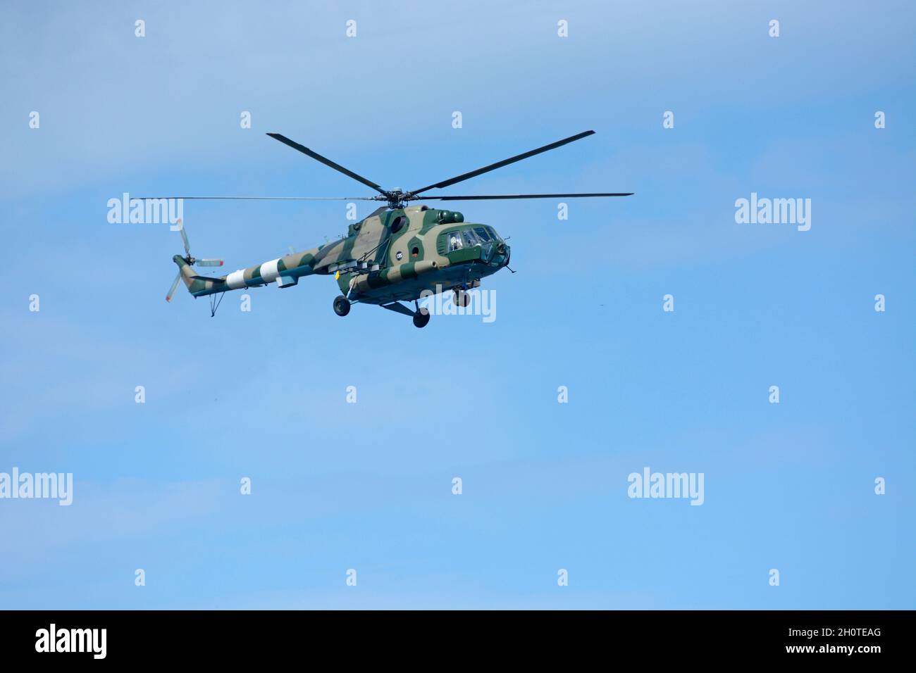 Military battle helicopter flying in a blue sky Stock Photo - Alamy