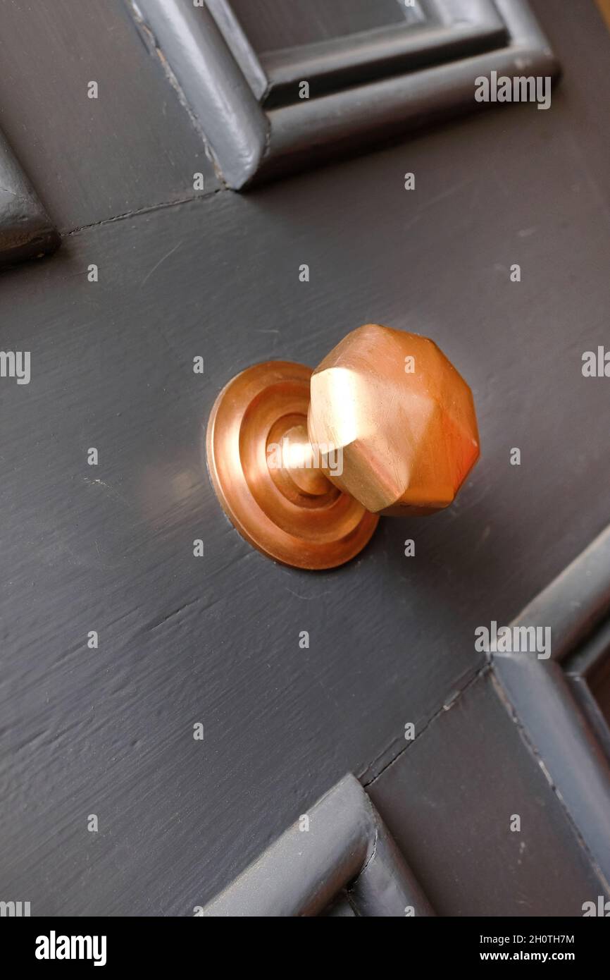 A bronze ornate door handle on a dark grey wooden front door Stock ...