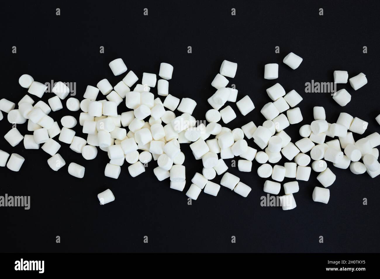 pile of marshmallows on black background, flat lay or top view ...