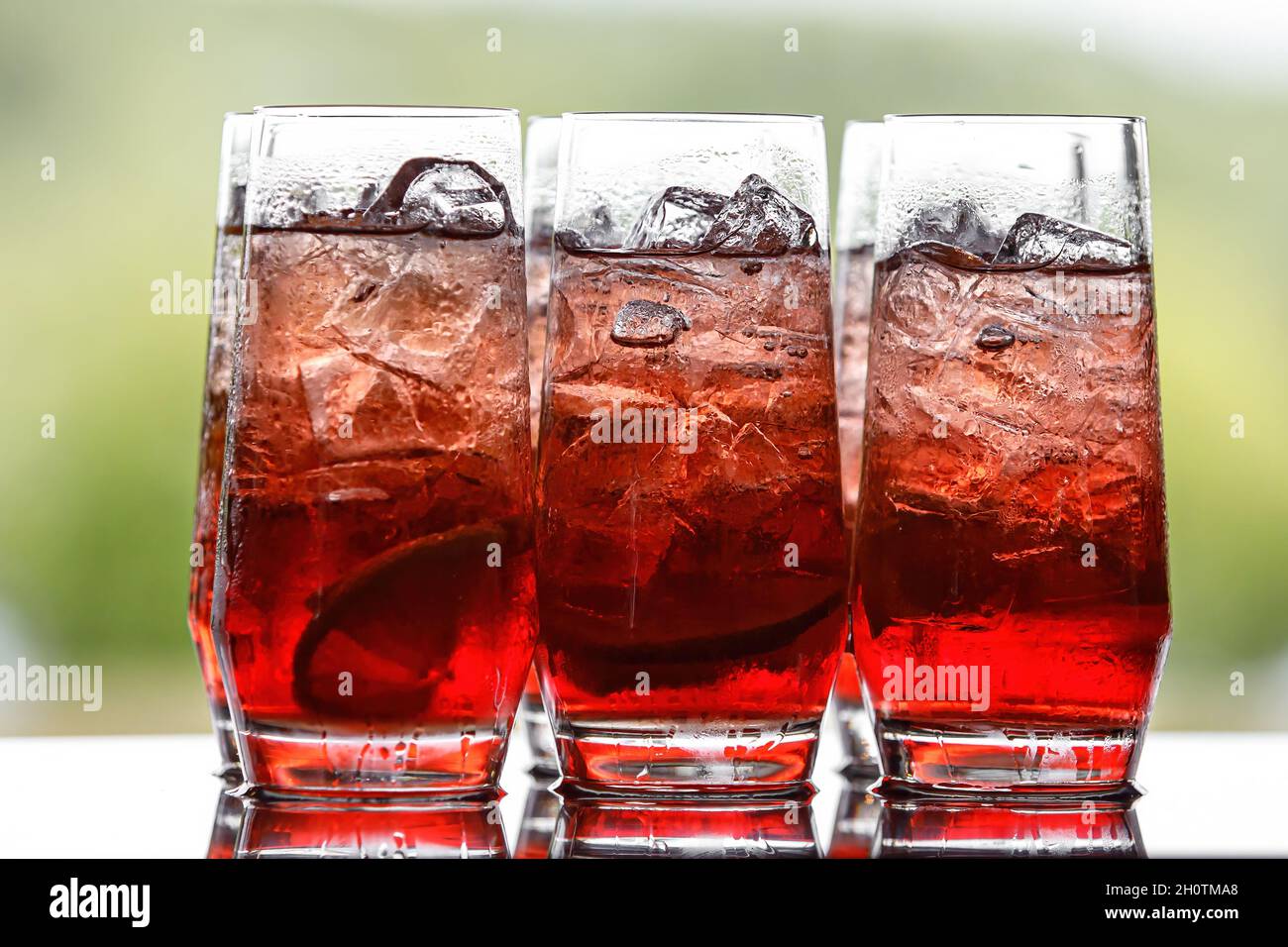 Glass of red lemonade with ice Stock Photo - Alamy