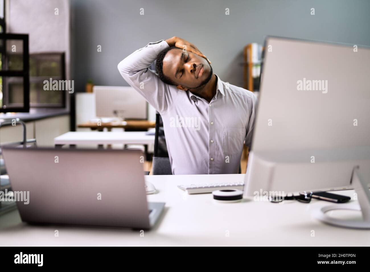 Employee Stretching At Office Desk At Work Stock Photo - Alamy
