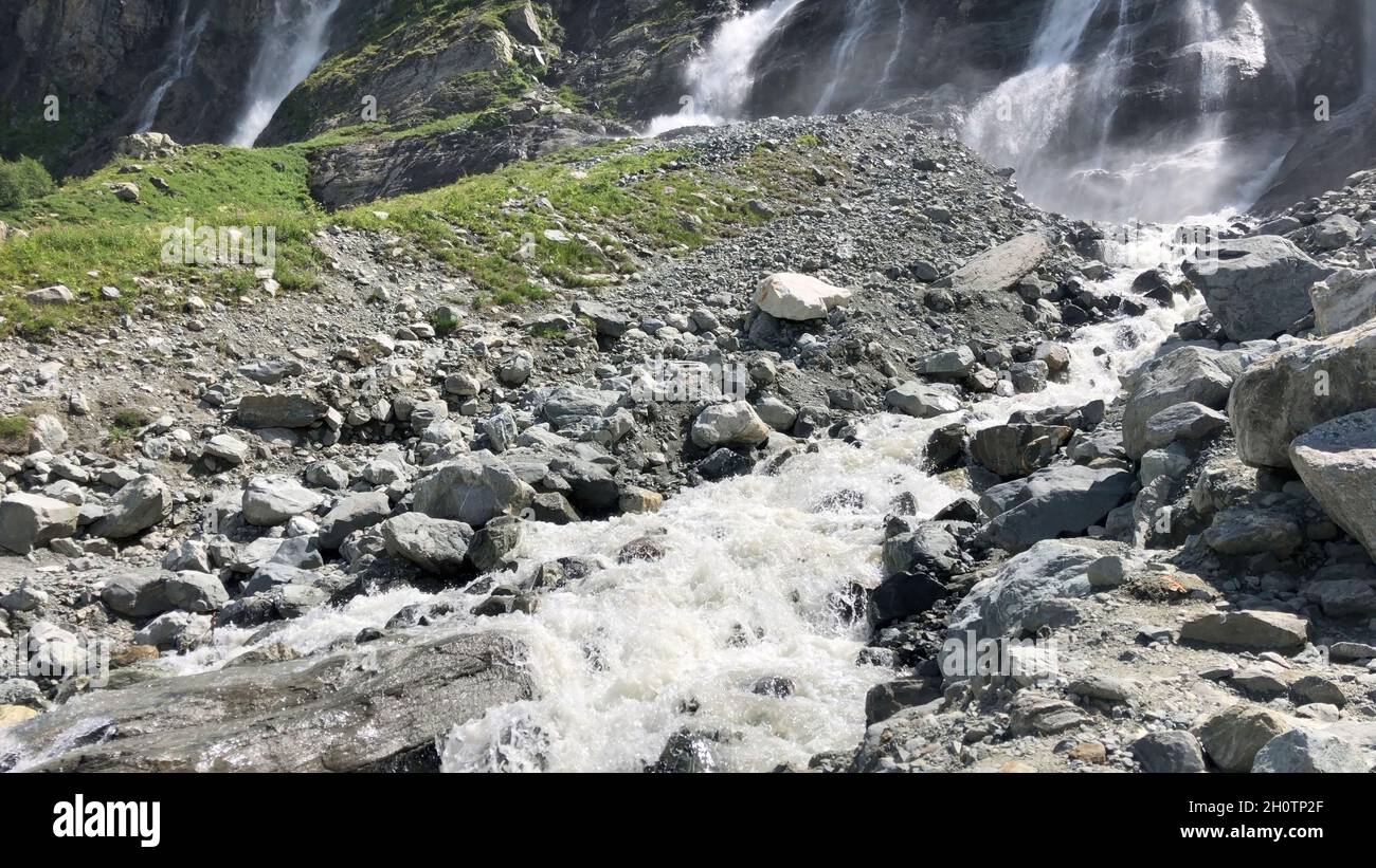 Mountain waterfall. Water streams falling over rocks in the sunlight ...