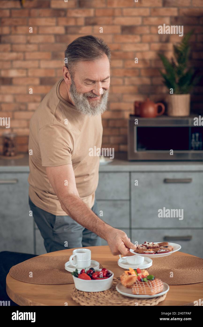 A man getting the breakfast ready and looking involved Stock Photo - Alamy