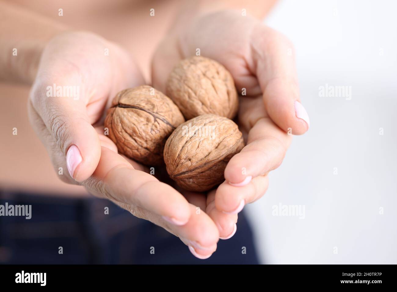 Three ripe walnuts in female hands closeup Stock Photo - Alamy