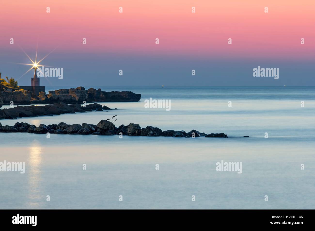 Sunset over rocks lighthouse hi-res stock photography and images - Alamy