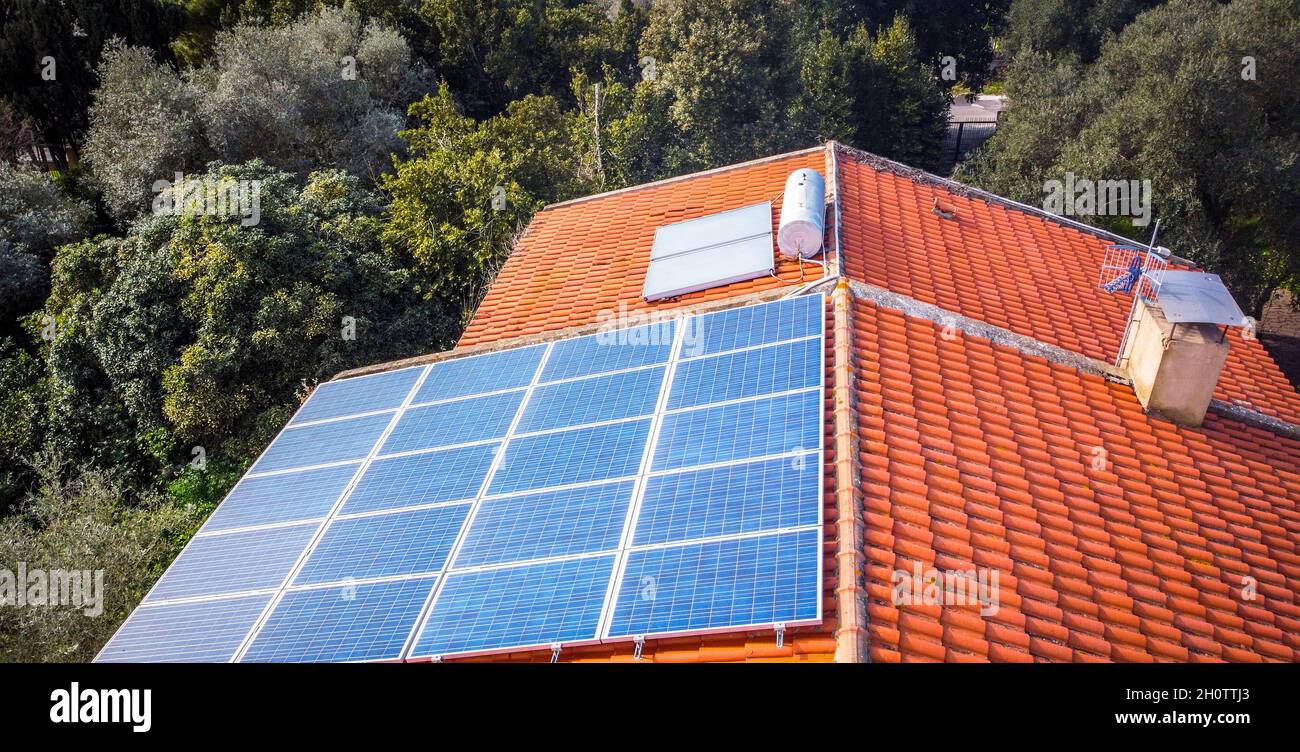 Aerial view of a private house with photovoltaic and solar panels on ...