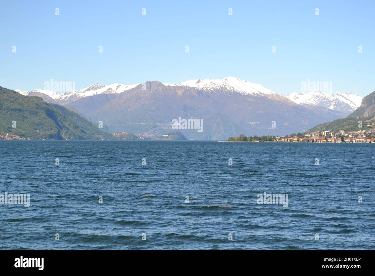 Village on lake como with snow capped mountain in lombardy hi-res stock ...