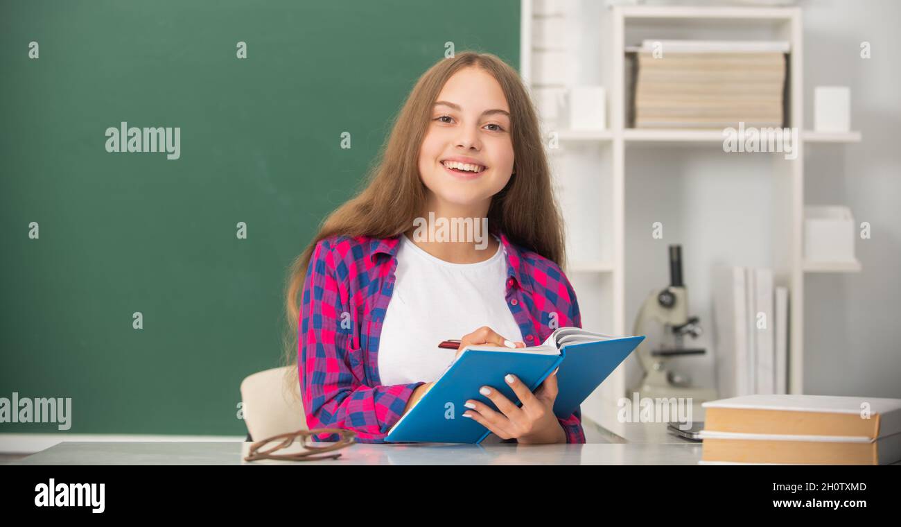 happy schoolgirl with copybook. child making notes in notebook. back to ...