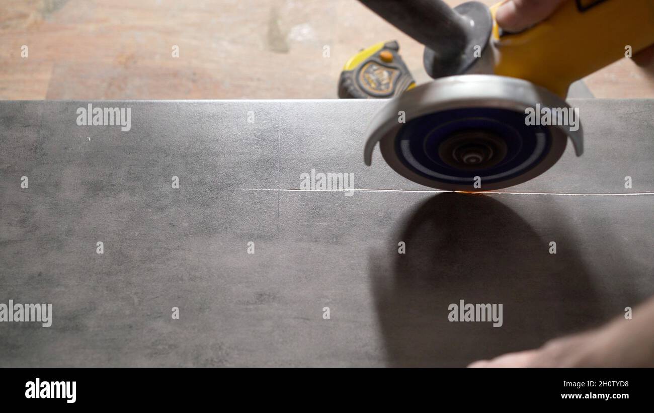 A worker is sawing ceramic tiles. Industry close up professional hand ...