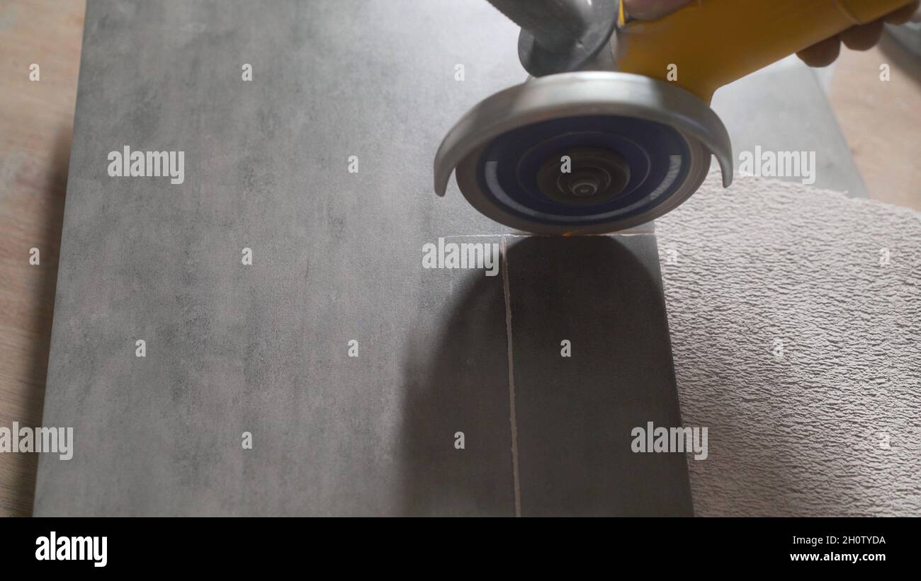 A worker is sawing ceramic tiles. Industry close up professional hand ...