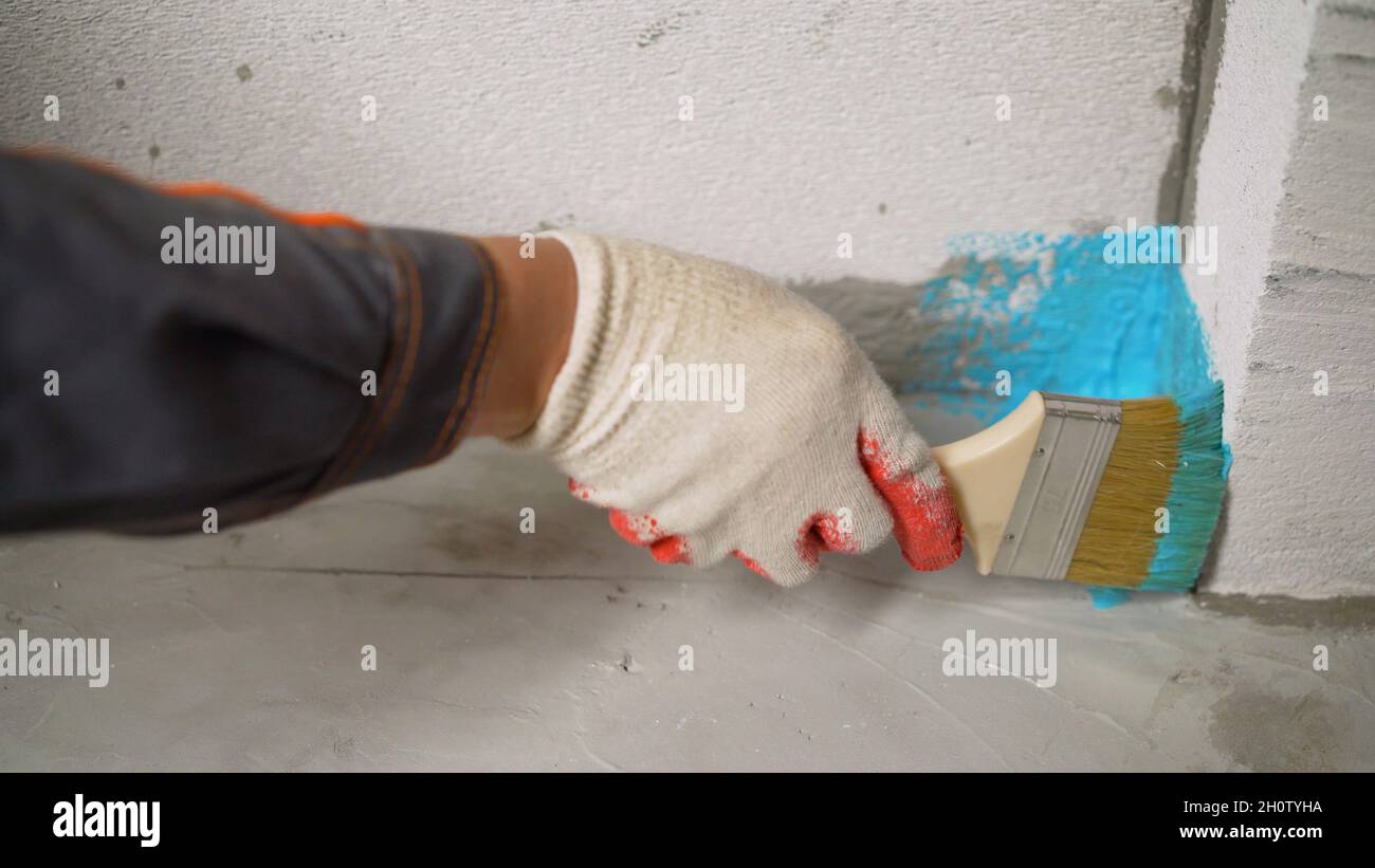 The process of applying waterproofing in the bathroom. A worker is ...