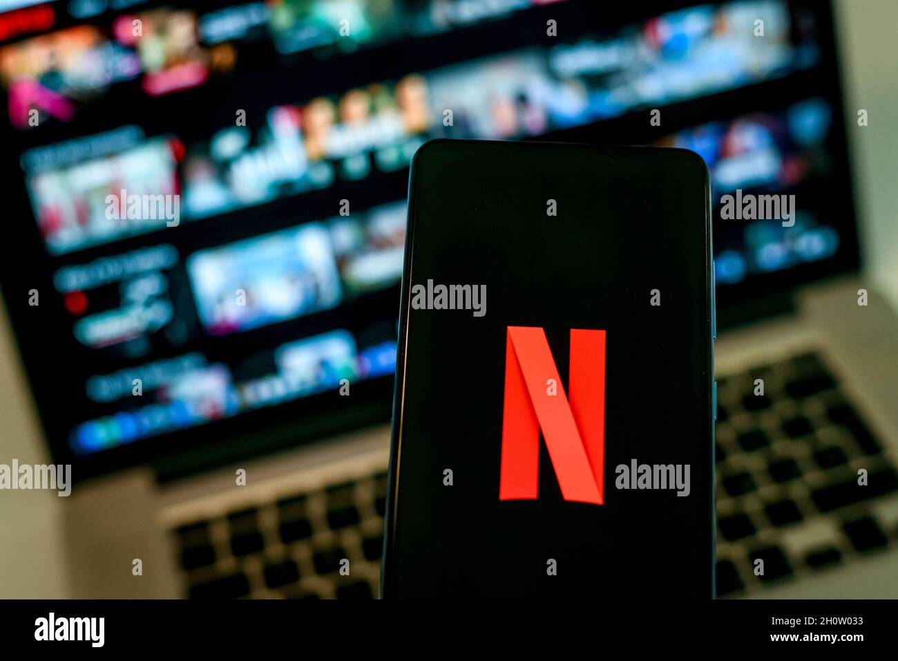 Close up view of a smartphone and Netflix logo on display. Computer on ...