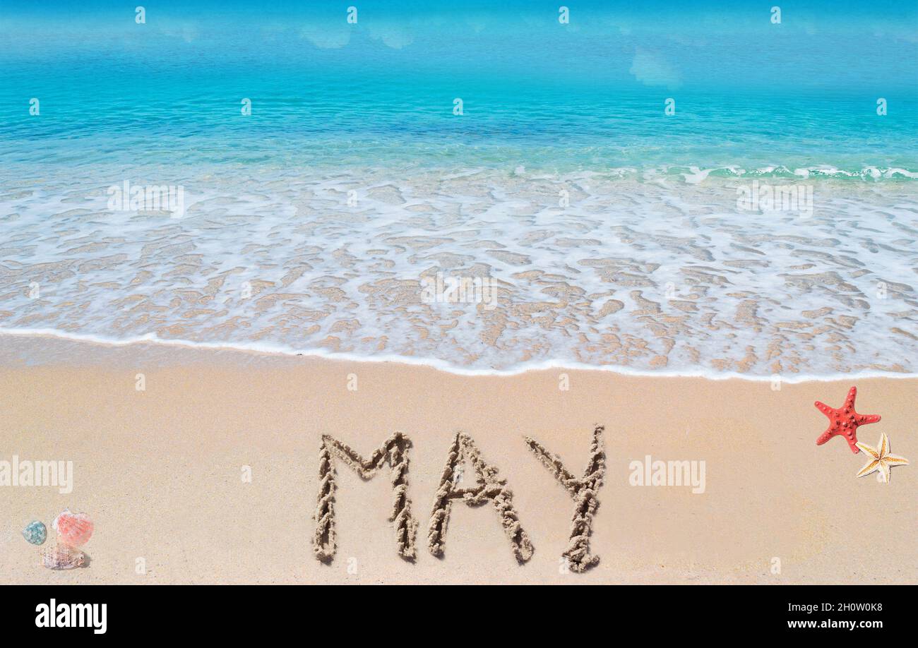 May written on a tropical beach under a blue sky Stock Photo - Alamy