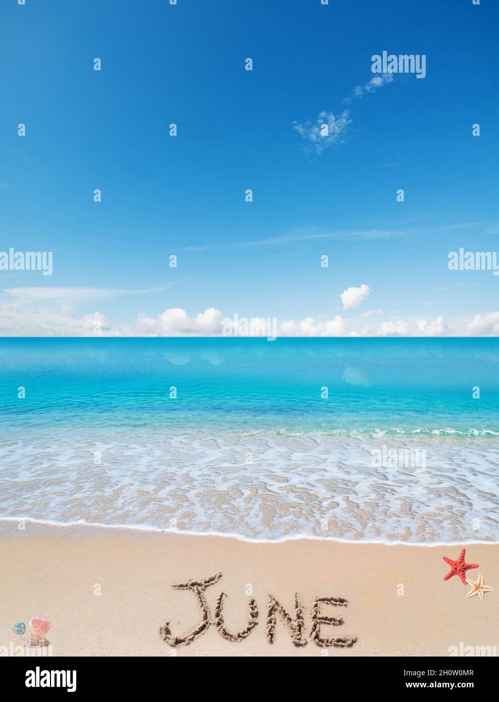 June written on a tropical beach under a blue sky Stock Photo - Alamy