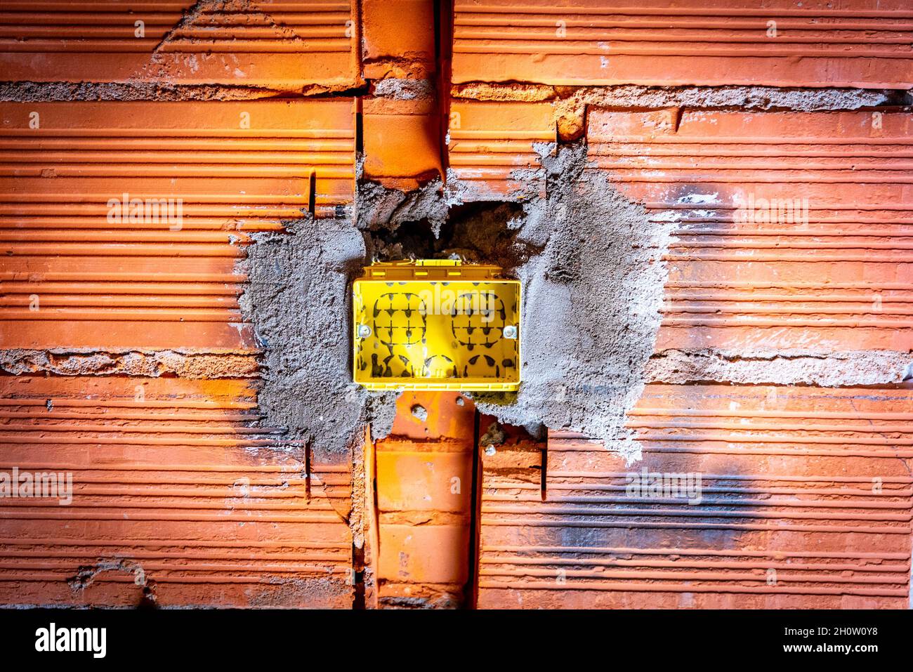 Close up of a yellow box for electrical plugs installation on an orange ...