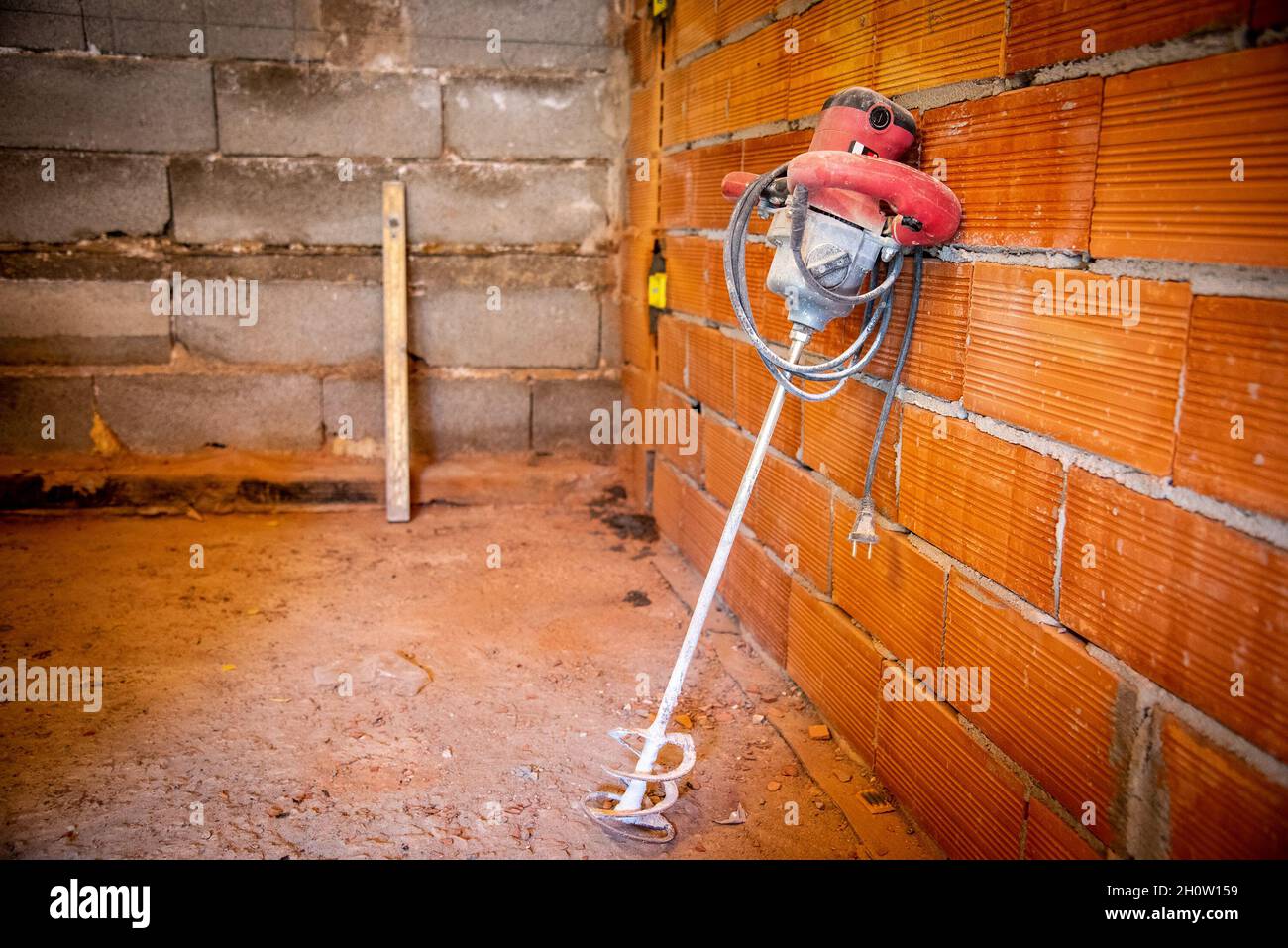 Electrical mixer leaning on an orange brick wall Stock Photo - Alamy