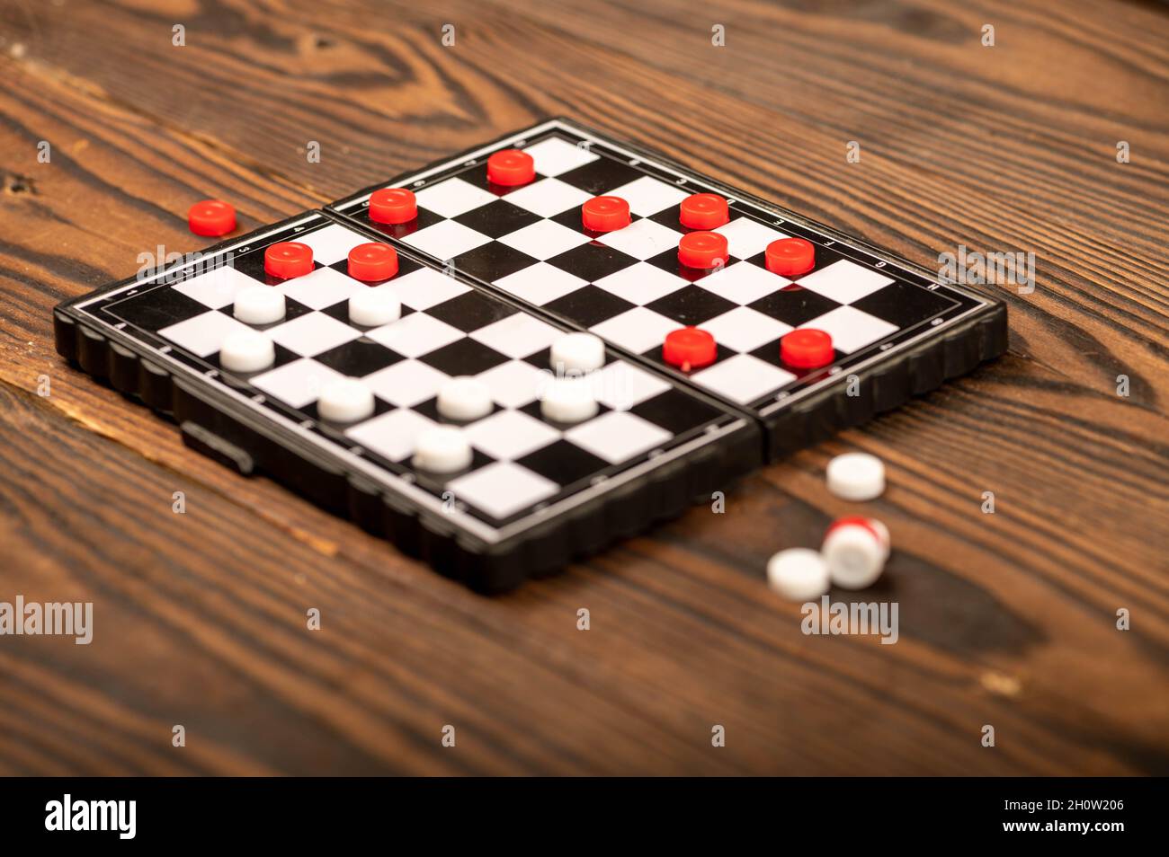 A board for playing checkers with chips on a wooden table, close-up ...