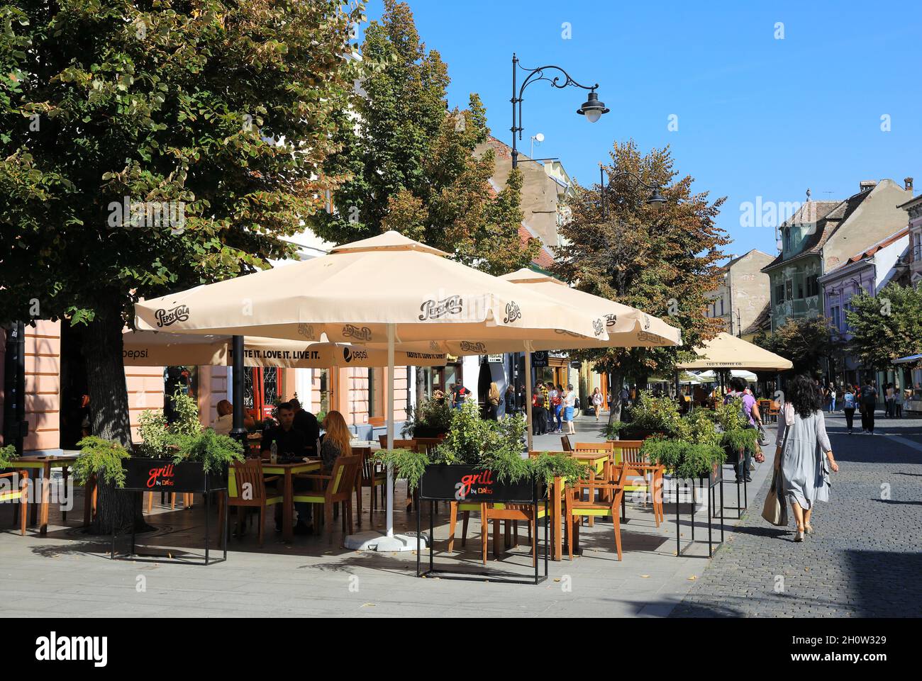 Cafes on Str Nicolae Balcescu in early autumn sunshine, in historical ...