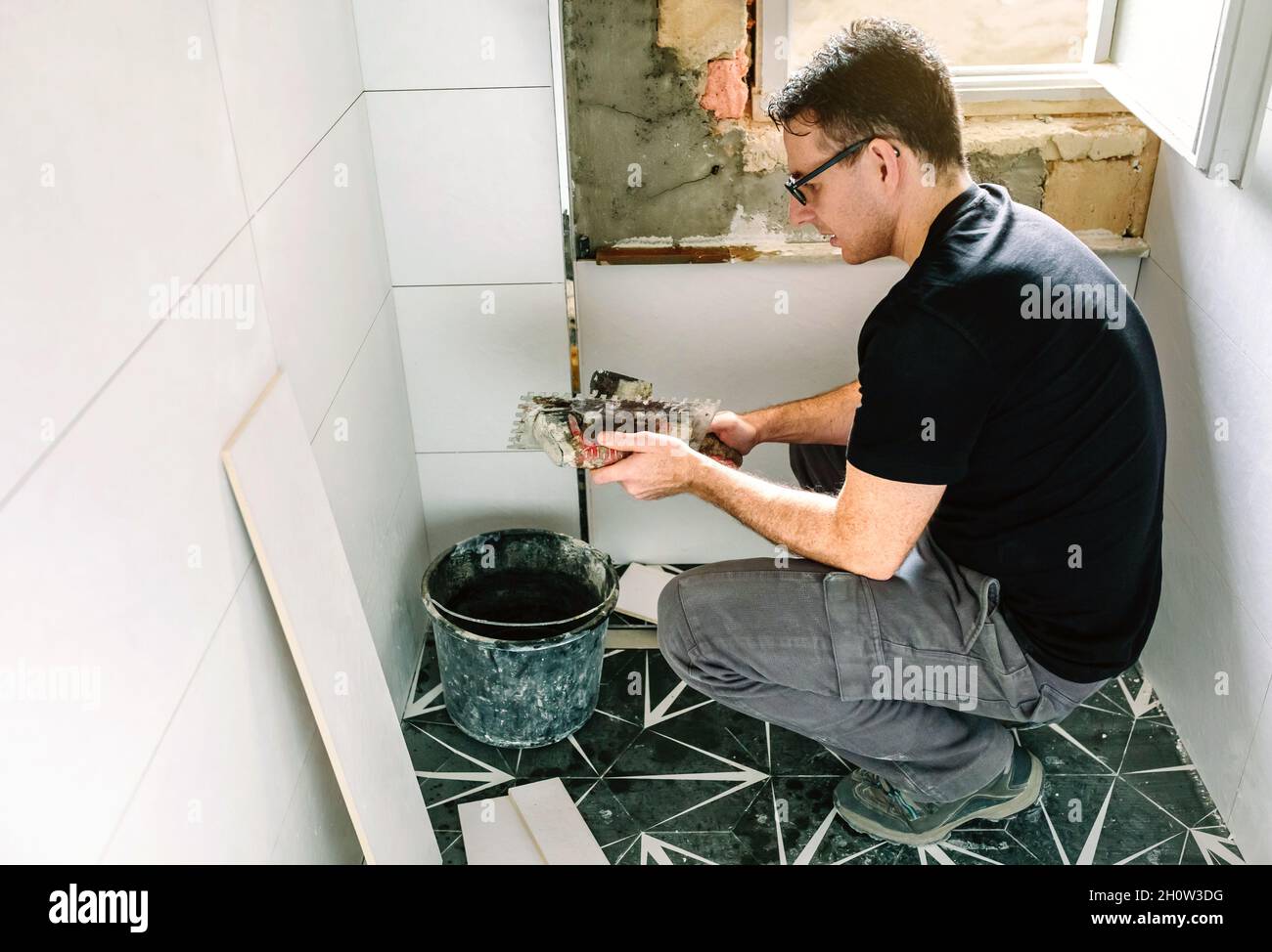 Mason working on a bathroom renovation Stock Photo - Alamy