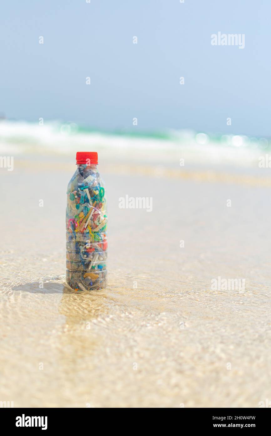 Vertical of a plastic bottle filled with collected microplastics on the ...