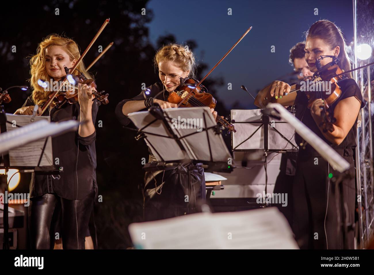 Female violin players playing in orchestra at night Stock Photo - Alamy