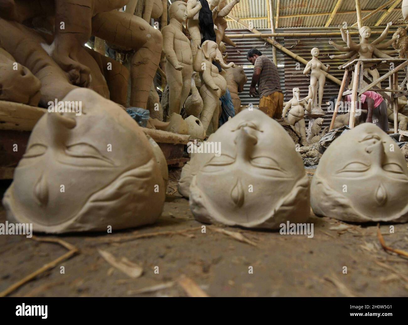 An idol maker making clay idols of Hindu deity Durga at a studio ahead ...