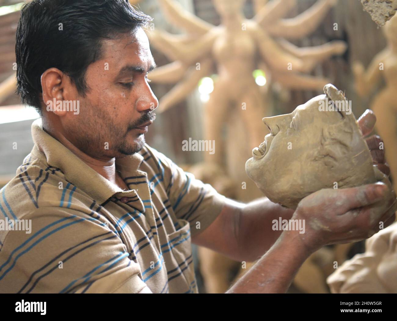 An idol maker making clay idols of Hindu deity Durga at a studio ahead ...