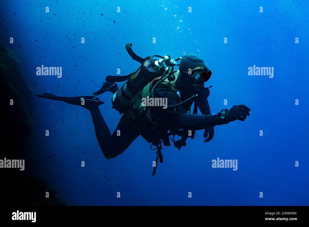 Scuba diver swimming in deep blue blue background Stock Photo - Alamy