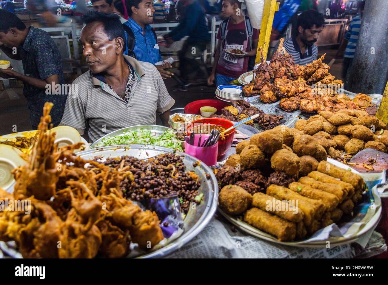 KHULNA, BANGLADESH - NOVEMBER 12, 2016: Street food seller at a market ...
