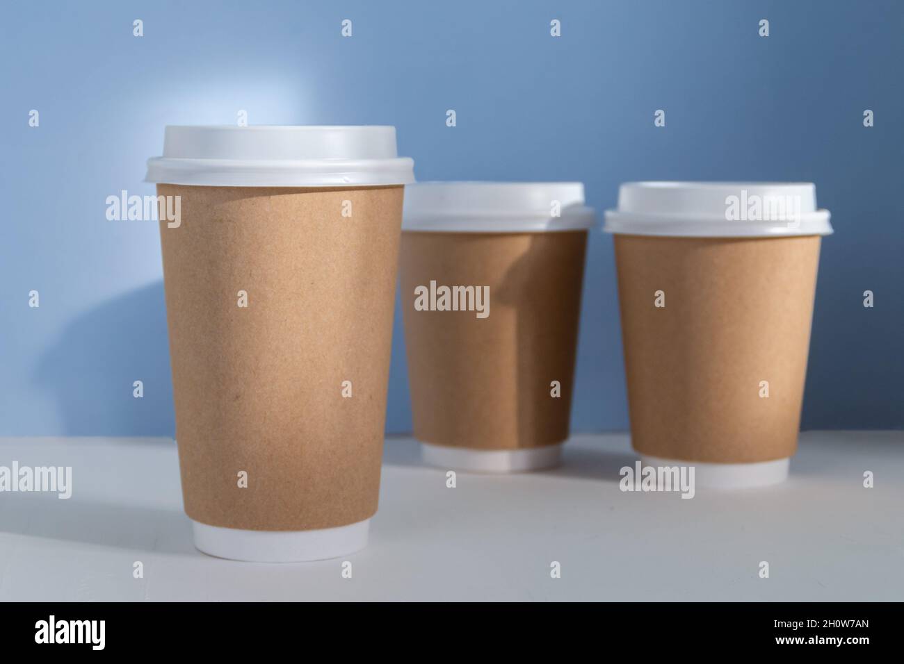 empty paper cup to go against light blue background Stock Photo - Alamy