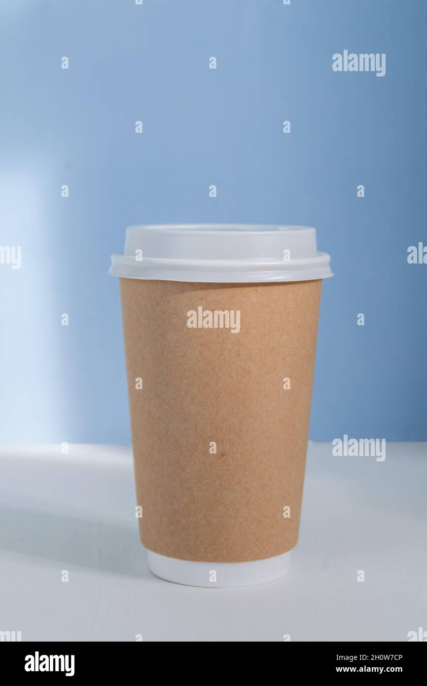 empty paper cup to go against light blue background Stock Photo - Alamy