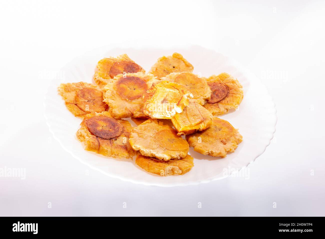 Pile of fried and smashed bananas on white background. Patacones ...