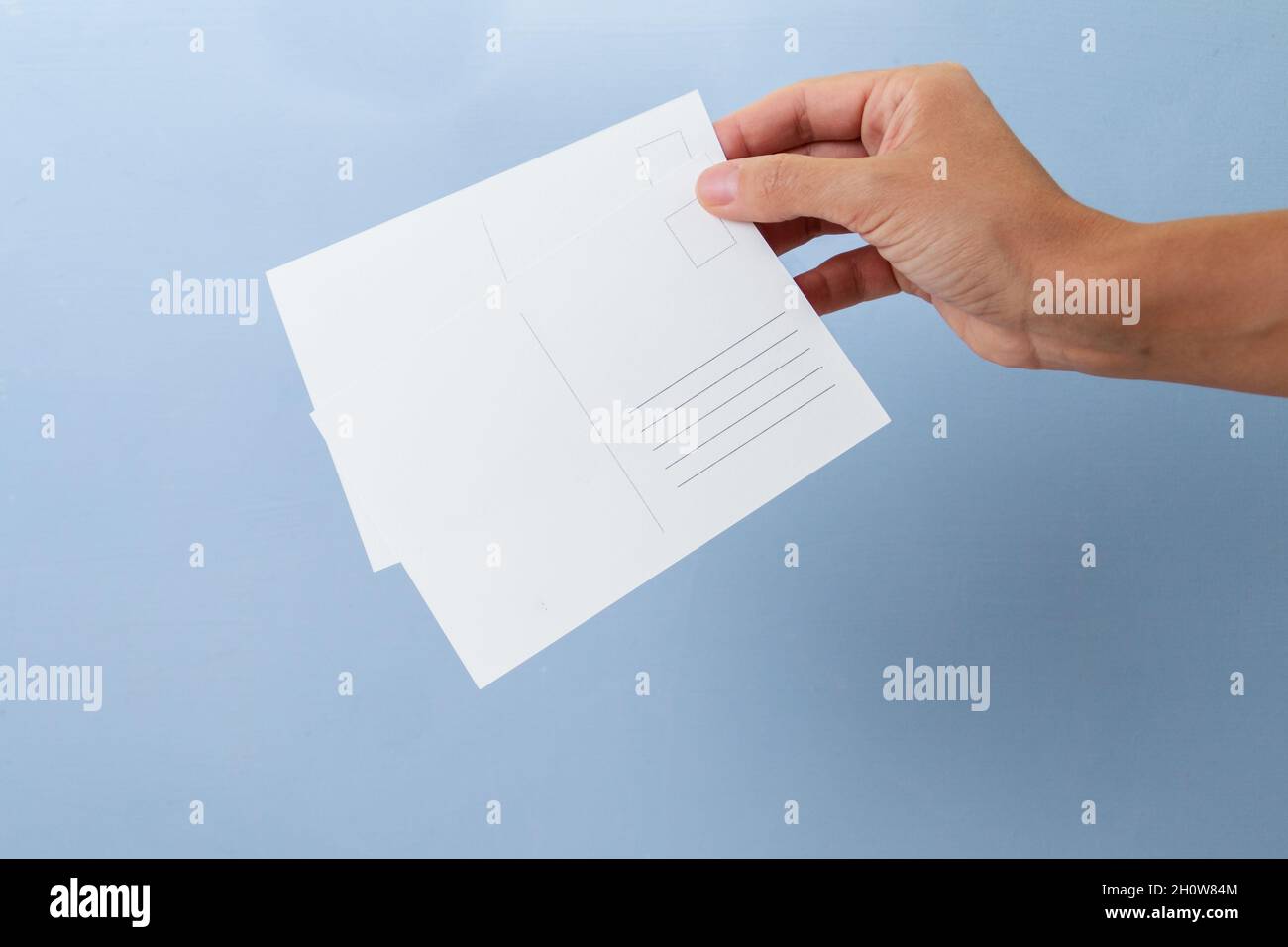 Empty greeting postcard against light blue background Stock Photo - Alamy