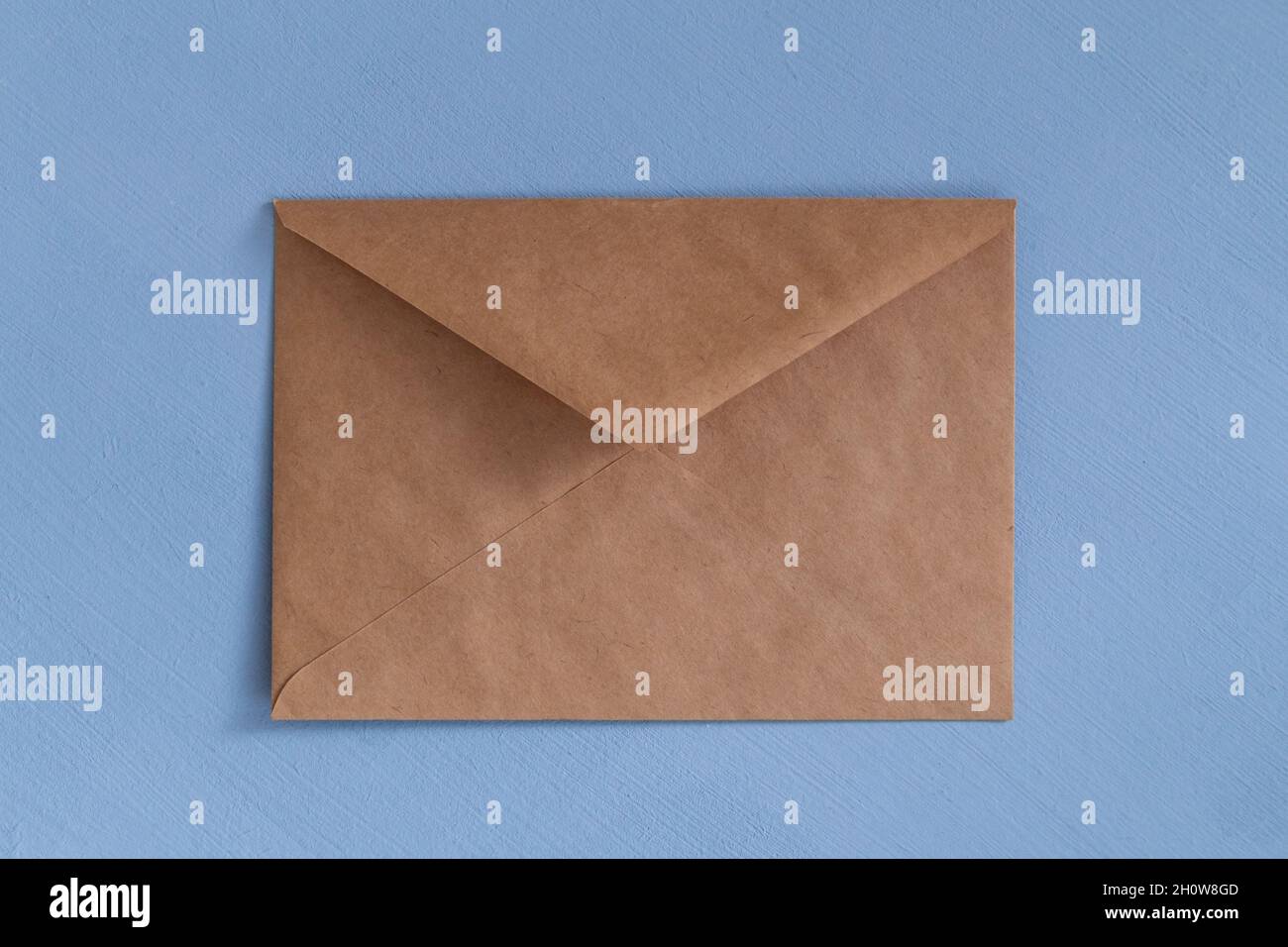 Empty paper craft envelop against light blue background Stock Photo - Alamy